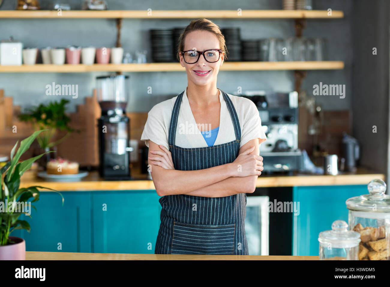 Portrait of smiling waitress standing with arms crossed Stock Photo - Alamy