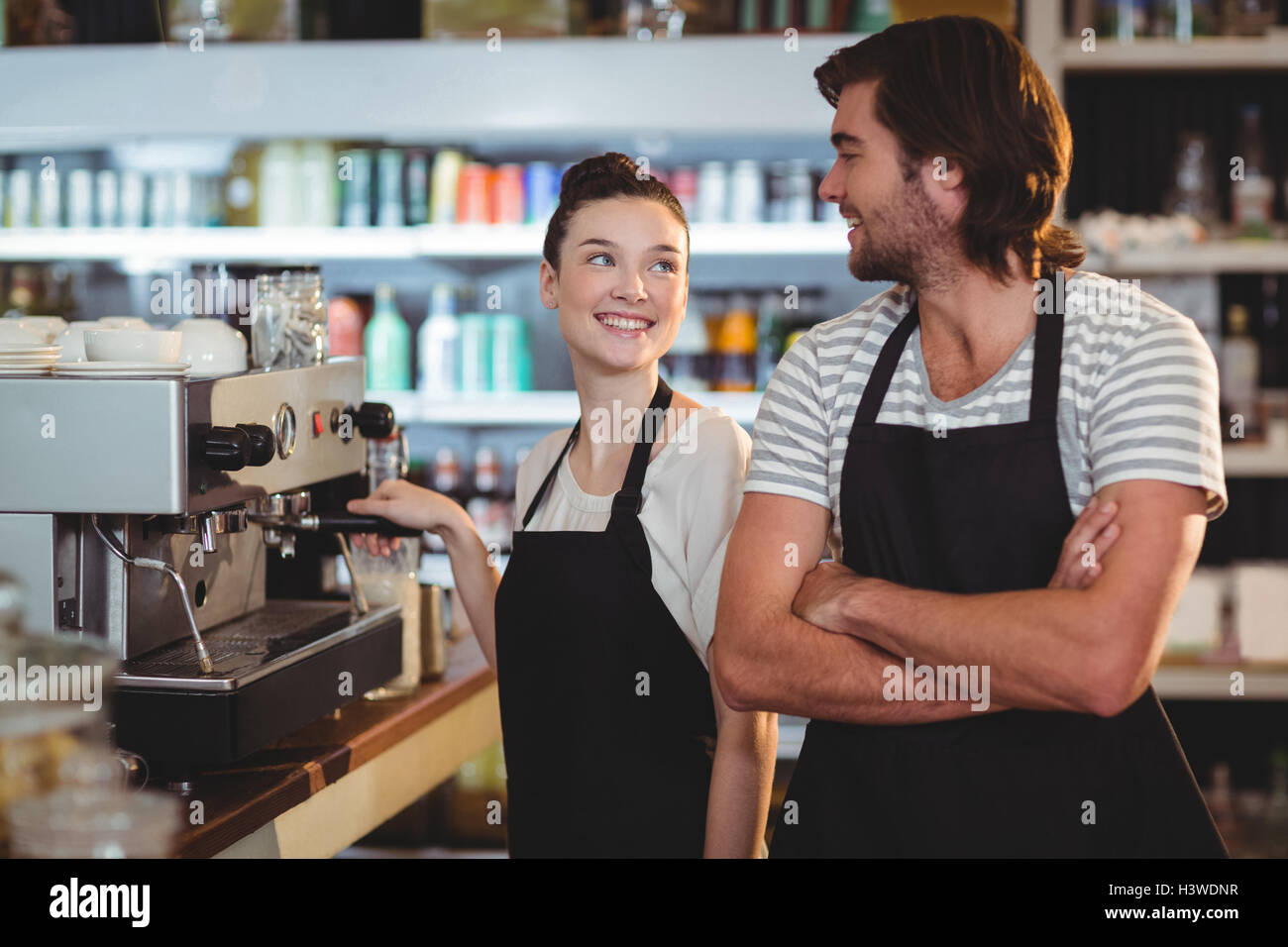 Waiter and waitress smiling at each other Stock Photo - Alamy