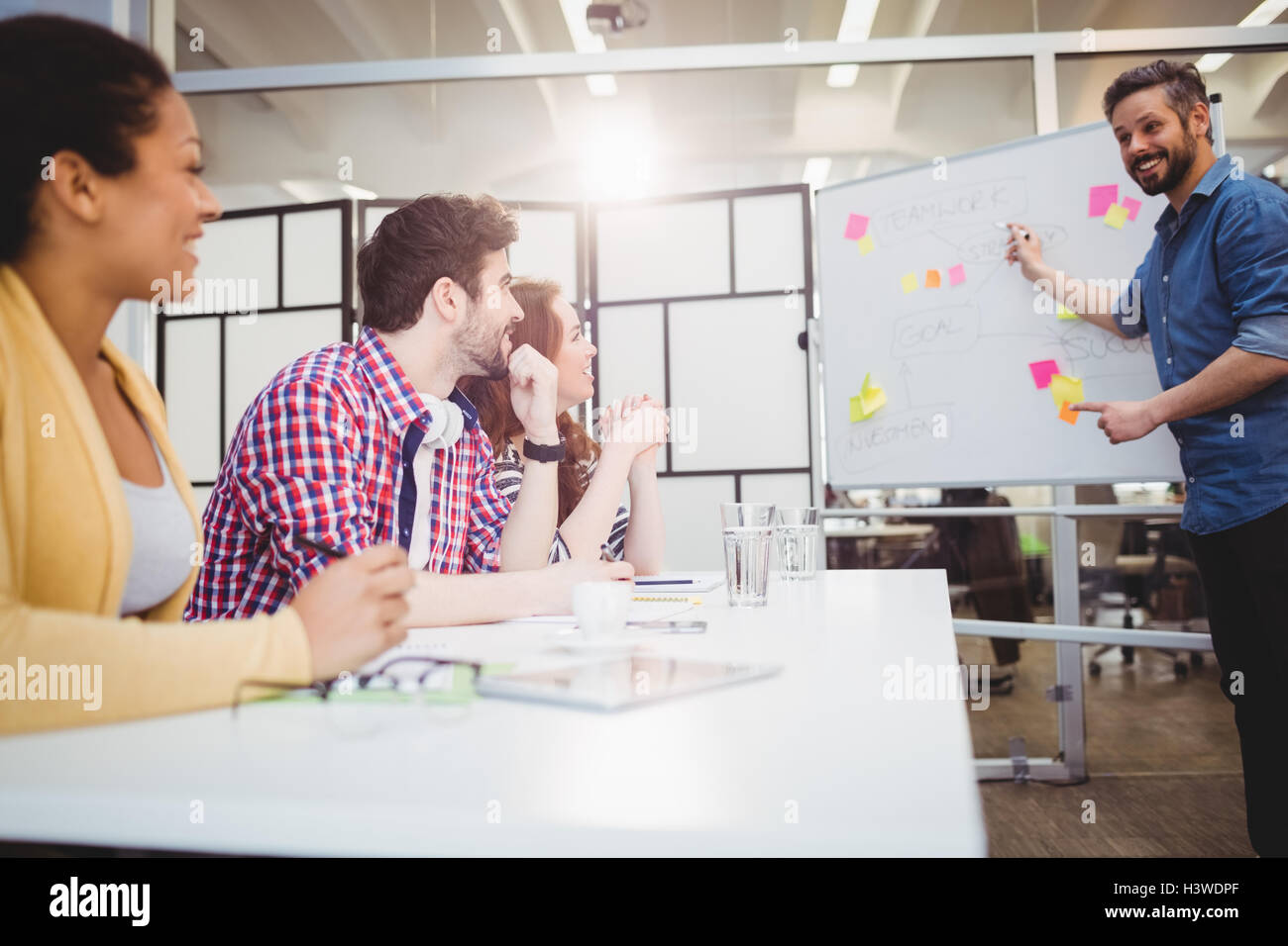 Happy executive explaining colleagues at creative office Stock Photo ...
