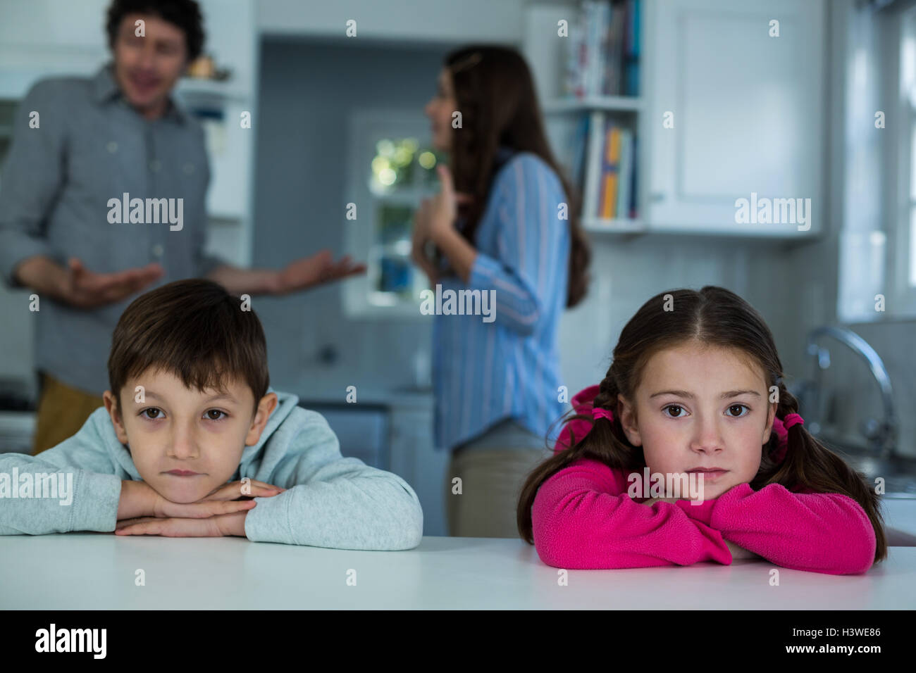 Upset children sitting while couple arguing with each other Stock Photo ...