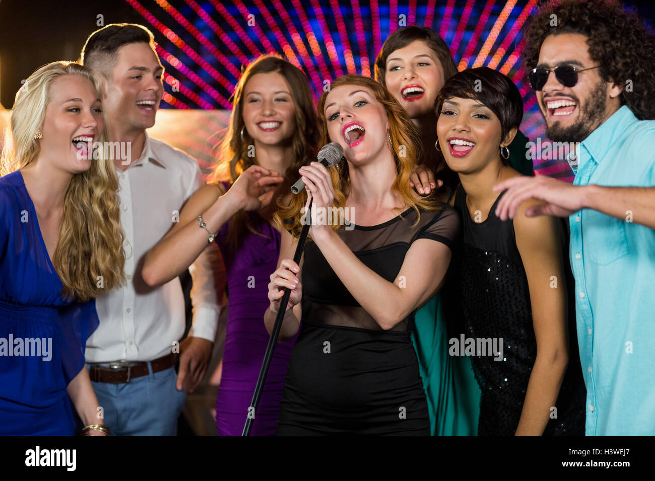Group of friends singing song together in bar Stock Photo - Alamy
