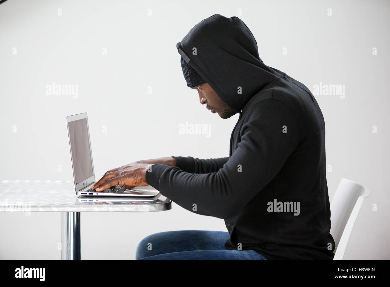 Hacker using a laptop Stock Photo - Alamy