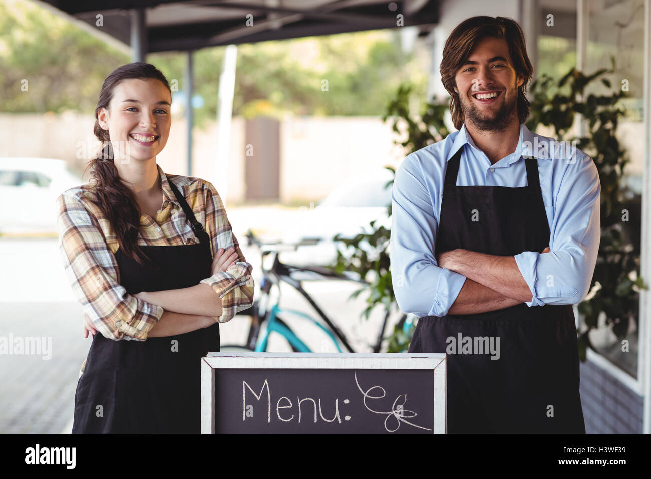 Waiter and waitress standing with menu board outside the cafe Stock ...