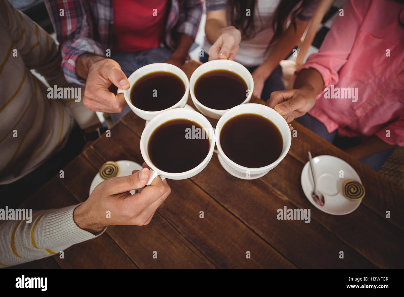 Group of friends toasting cup of coffee Stock Photo - Alamy