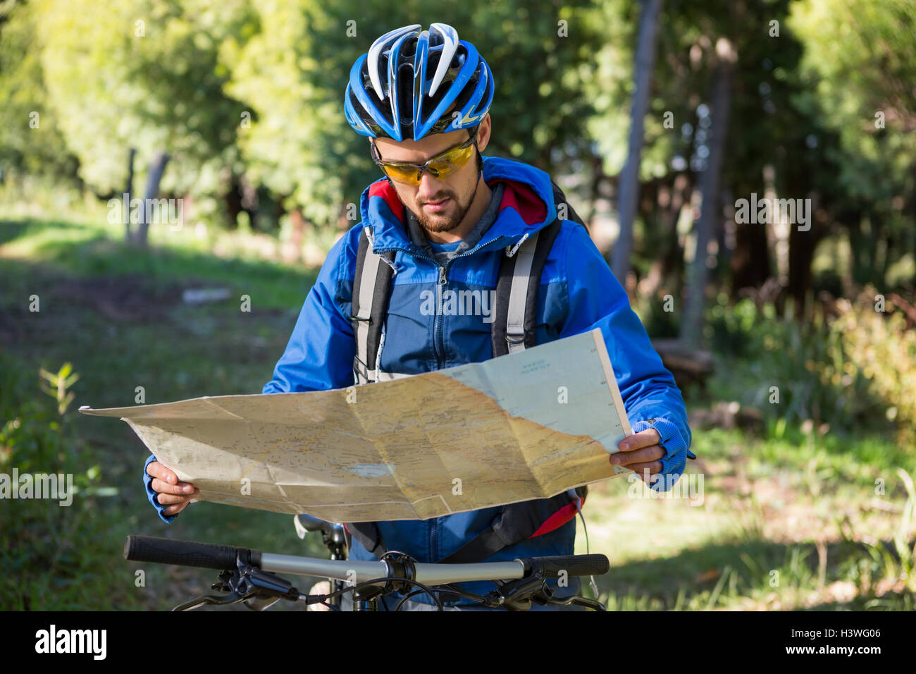 Male mountain biker looking at map Stock Photo - Alamy