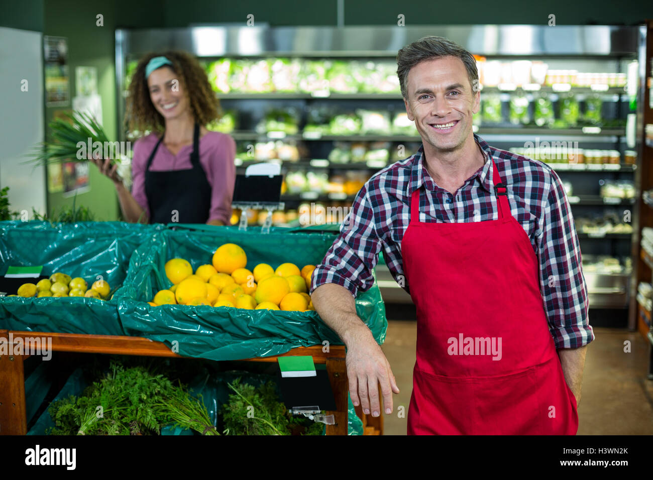 Smiling male staff standing in organic section Stock Photo - Alamy