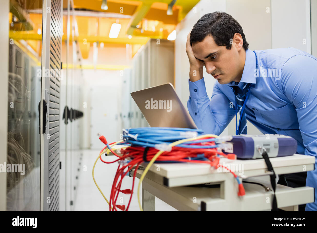 Stressed technician using laptop Stock Photo - Alamy