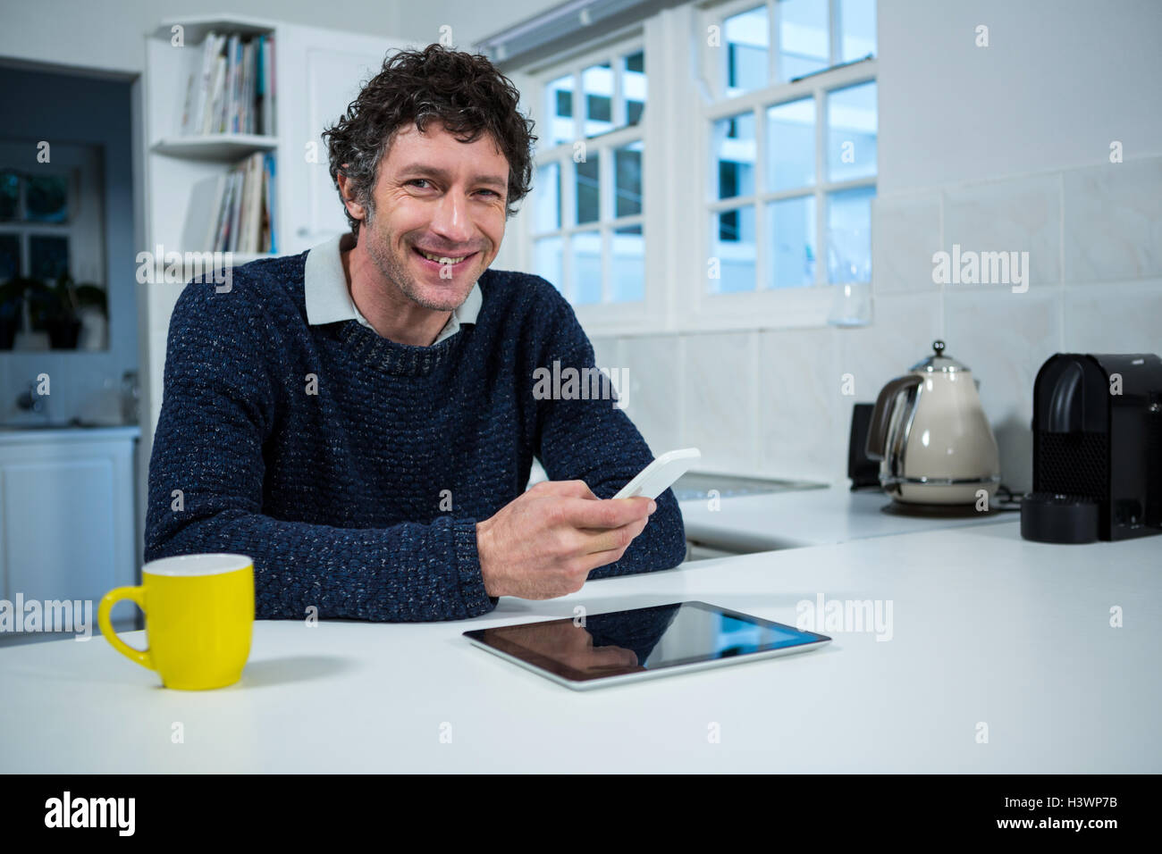 Man holding mobile phone in the kitchen Stock Photo - Alamy