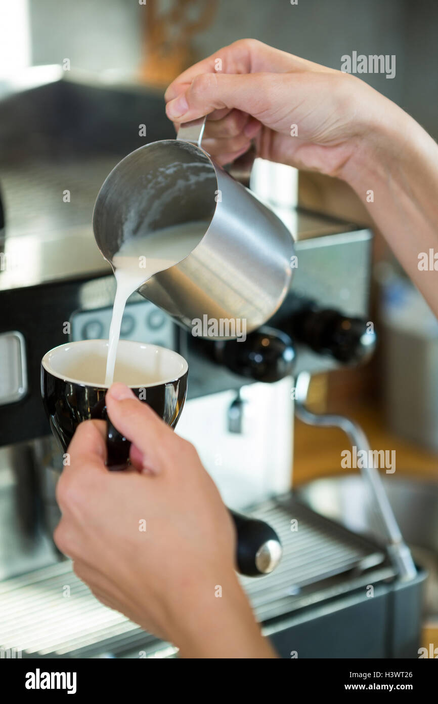 Waitress pouring milk in the cup Stock Photo - Alamy