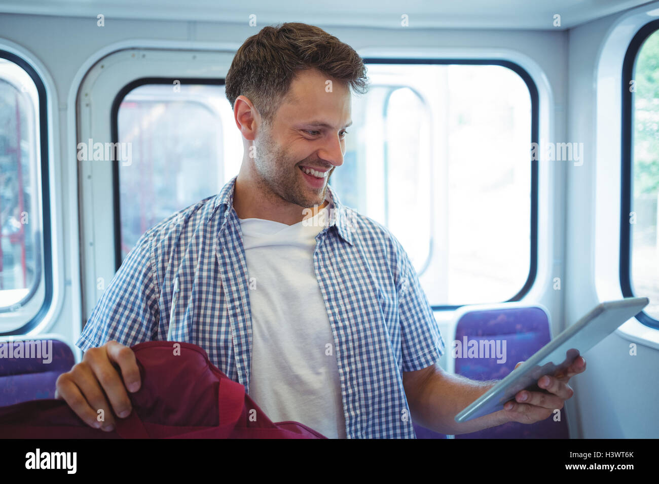 Handsome man using digital tablet in train Stock Photo - Alamy