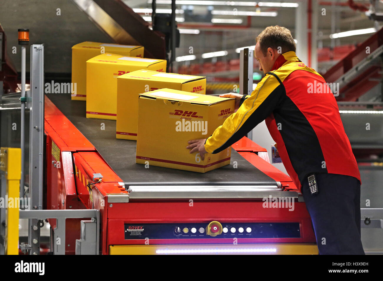 Schkeuditz, Germany. 12th Oct, 2016. A DHL employee puts a parcel onto ...