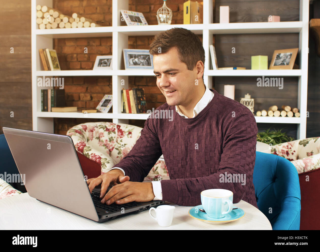 Happy young man smiling and works on his laptop Stock Photo - Alamy