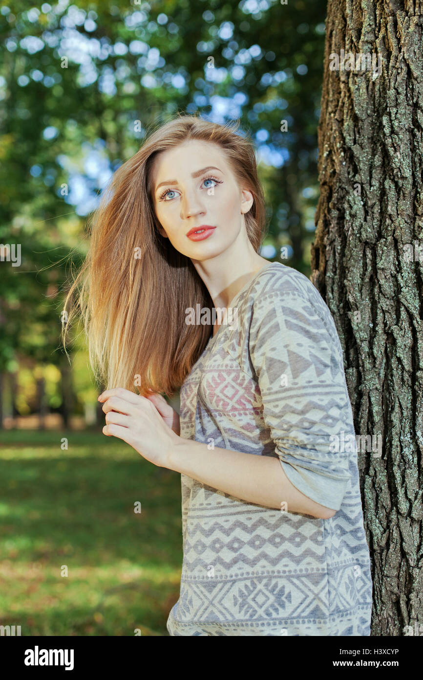 Beautiful elegant woman standing in a park in autumn Stock Photo - Alamy