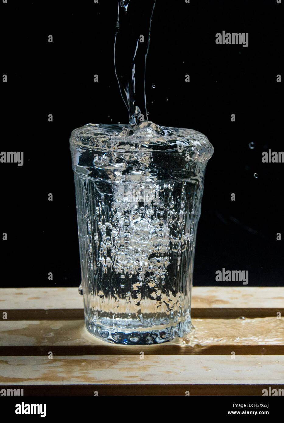 Water is poured into beaker on dark background Stock Photo - Alamy