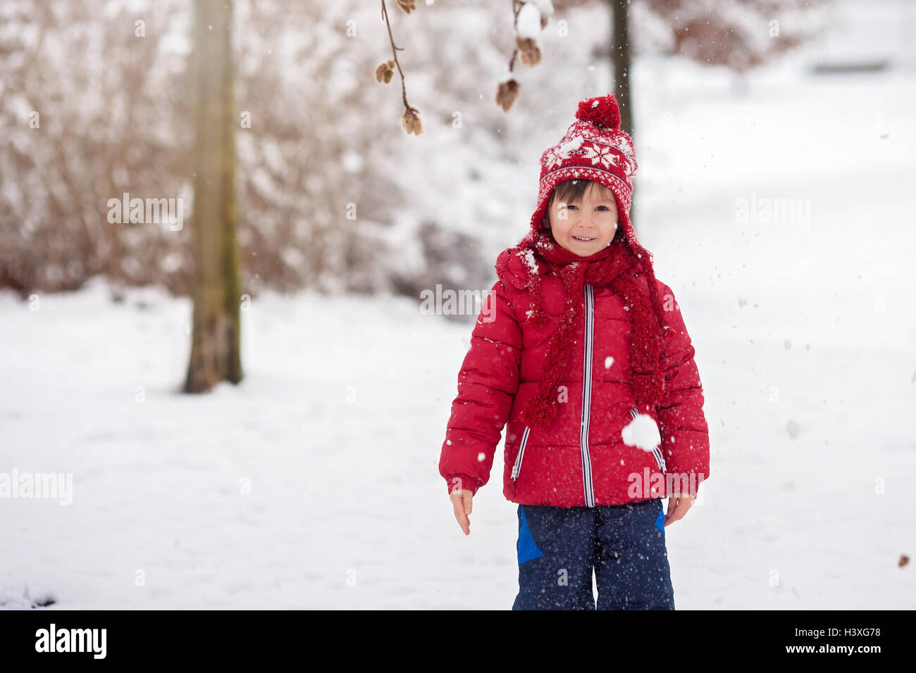 Cute little boy, playing in the snow in garden, wintertime Stock Photo ...