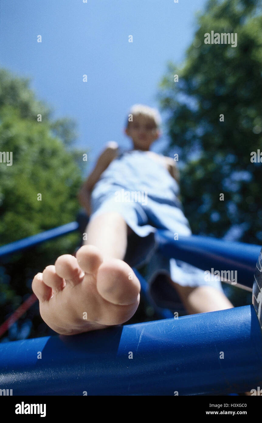Climbing frame, boy, barefoot, from below, very close, summer Stock ...