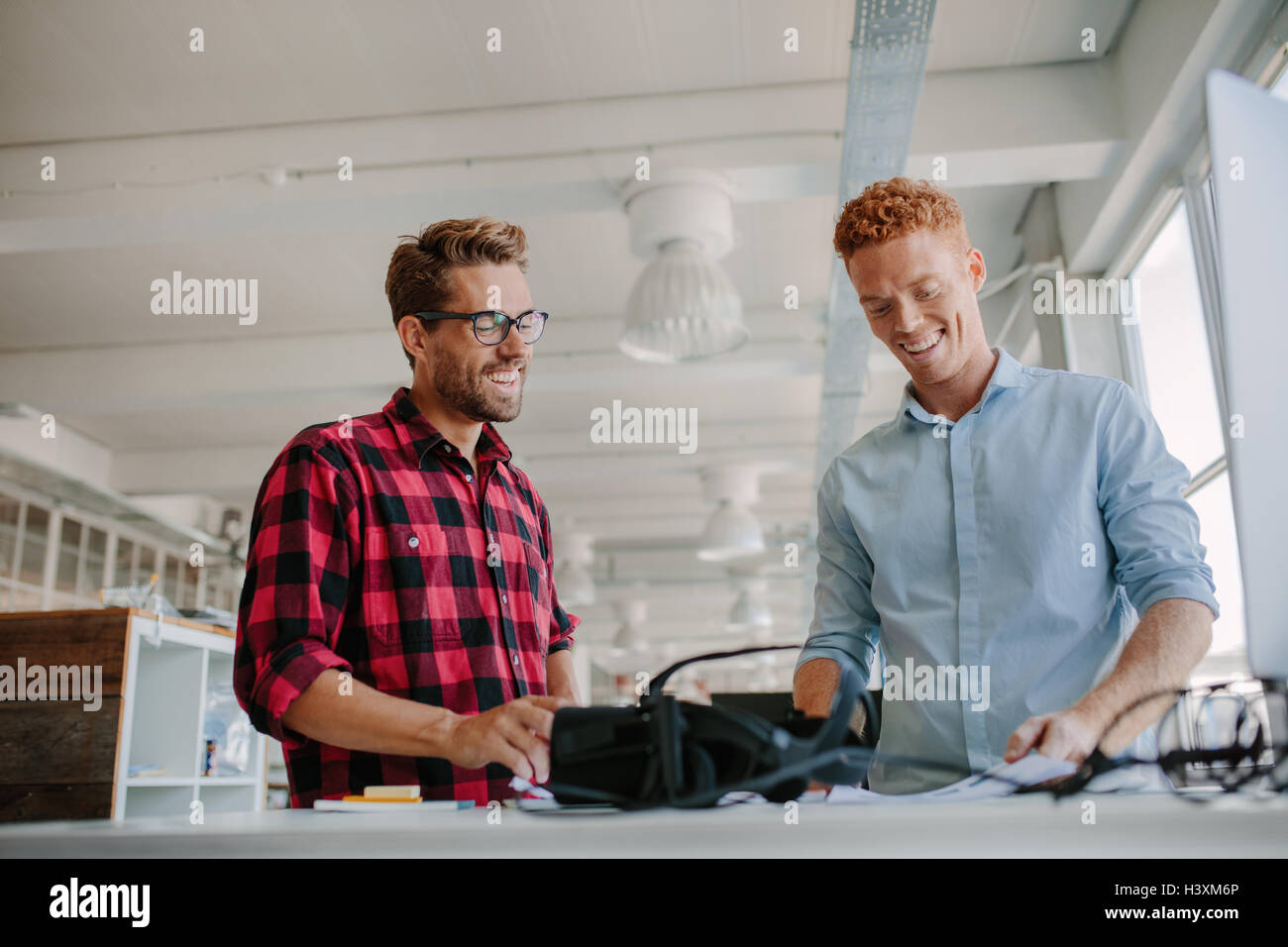 Shot of happy young man working together in modern office. Team of ...