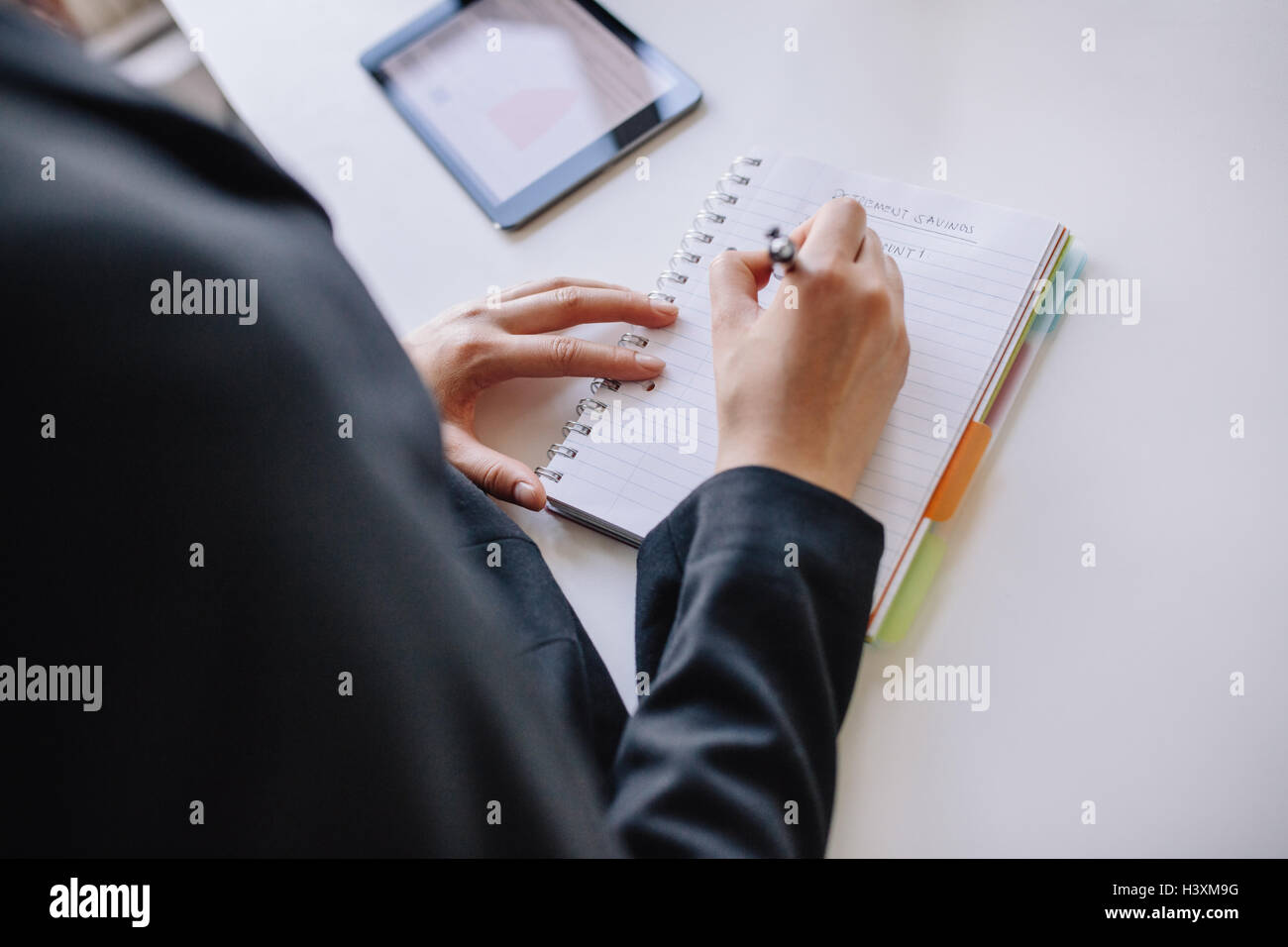 Close up shot of young businesswoman hands writing on notepad at office ...