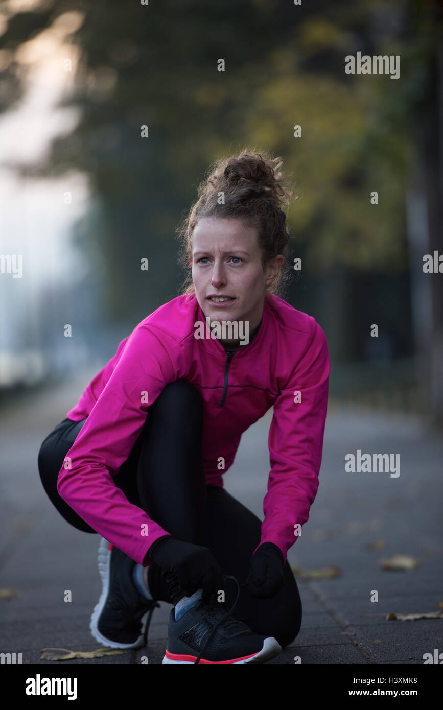 runner woman warming up and stretching before morning jogging Stock ...