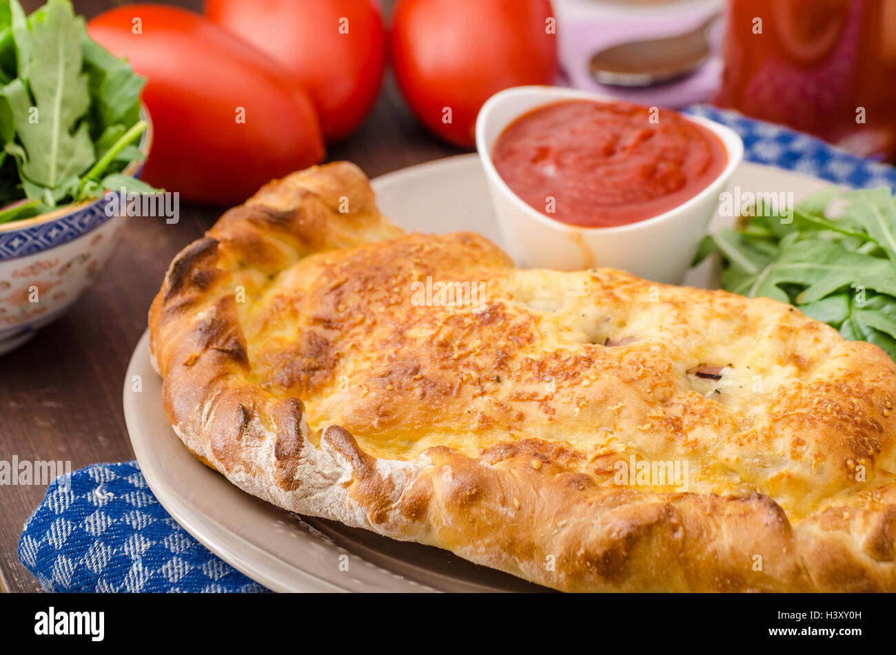 Calzone pizza stuffed with cheese and prosciutto, hot dip and summer ...