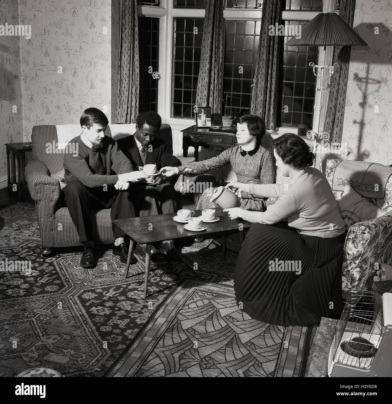 1950s, historical, guests to a house being served a cup of tea in the ...