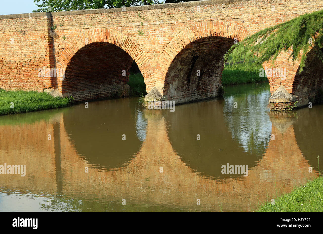ancient arched bridge made of red bricks with the river Stock Photo - Alamy