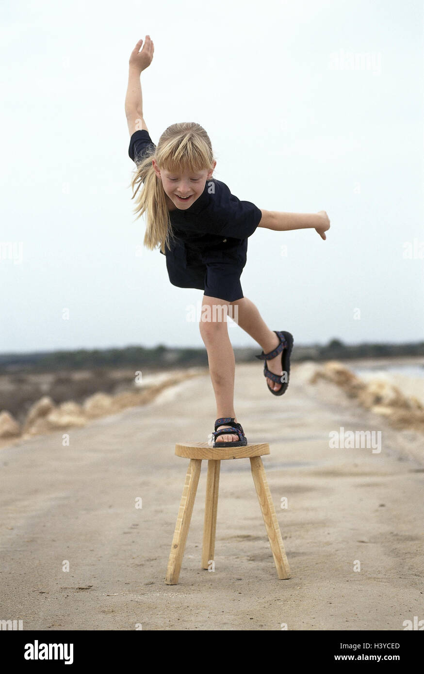 Girl balancing on stool hi-res stock photography and images - Alamy