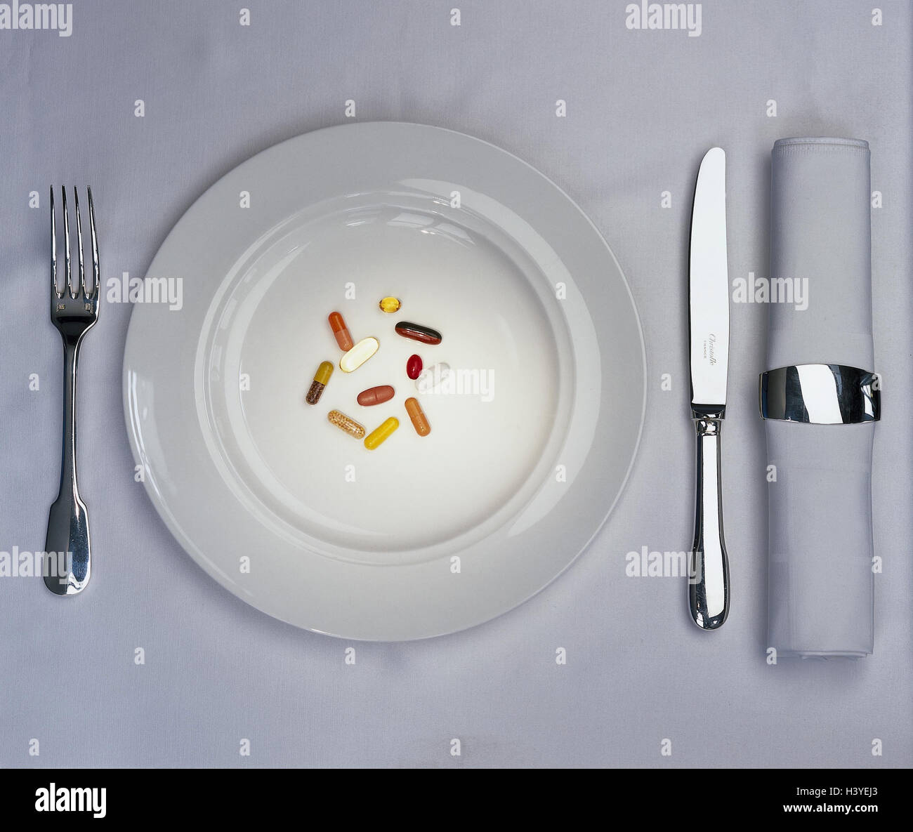 Table cover, plate, drugs, capsules, knives, fork, instruments, eating ...