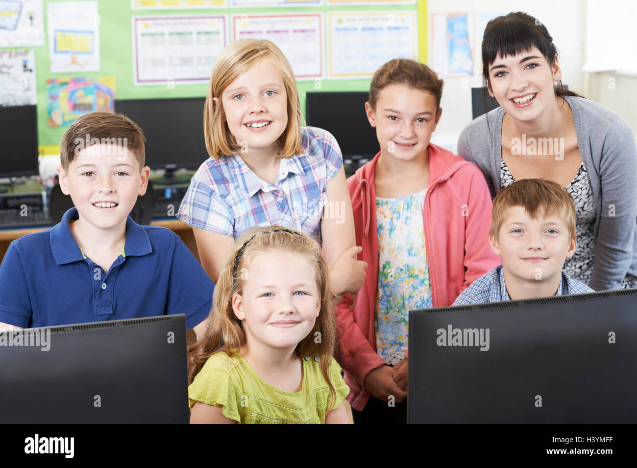 Portrait Of Elementary School Pupils With Teacher In Computer Class ...