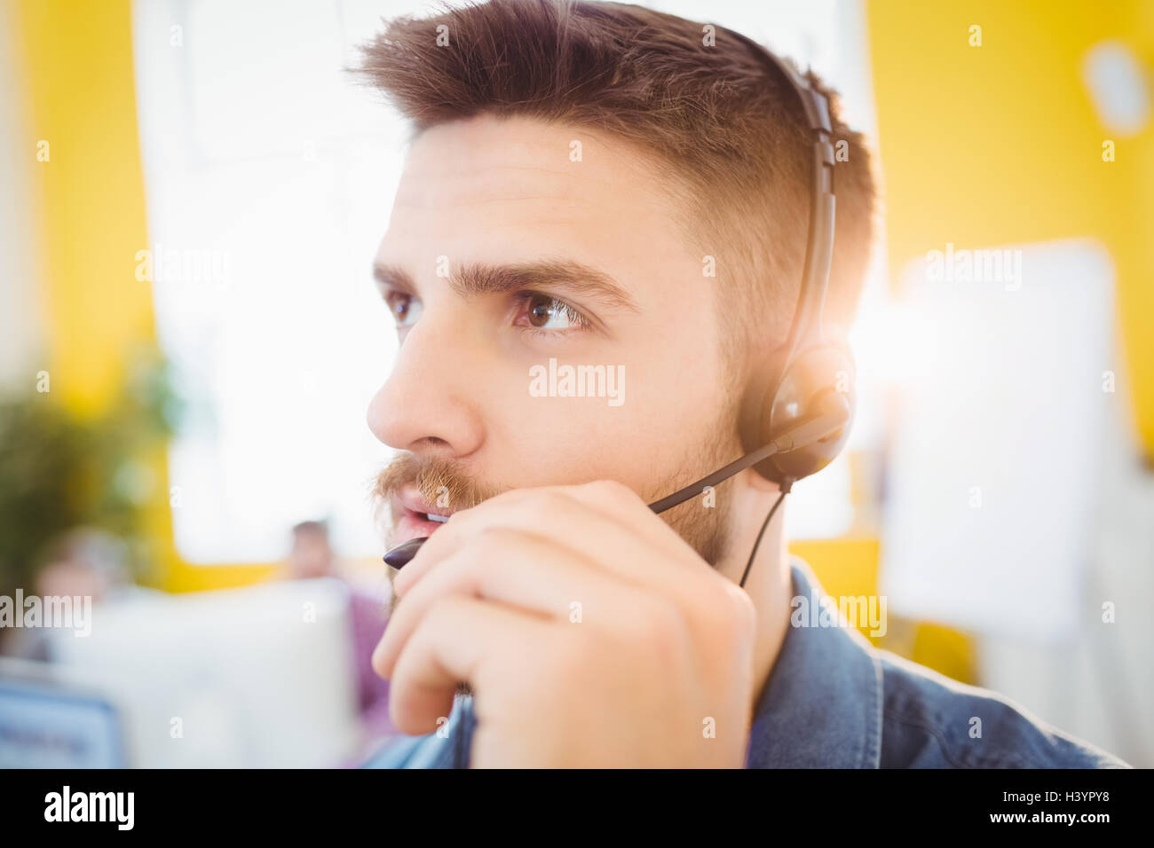 Close-up of executive interacting with headphones at creative office ...