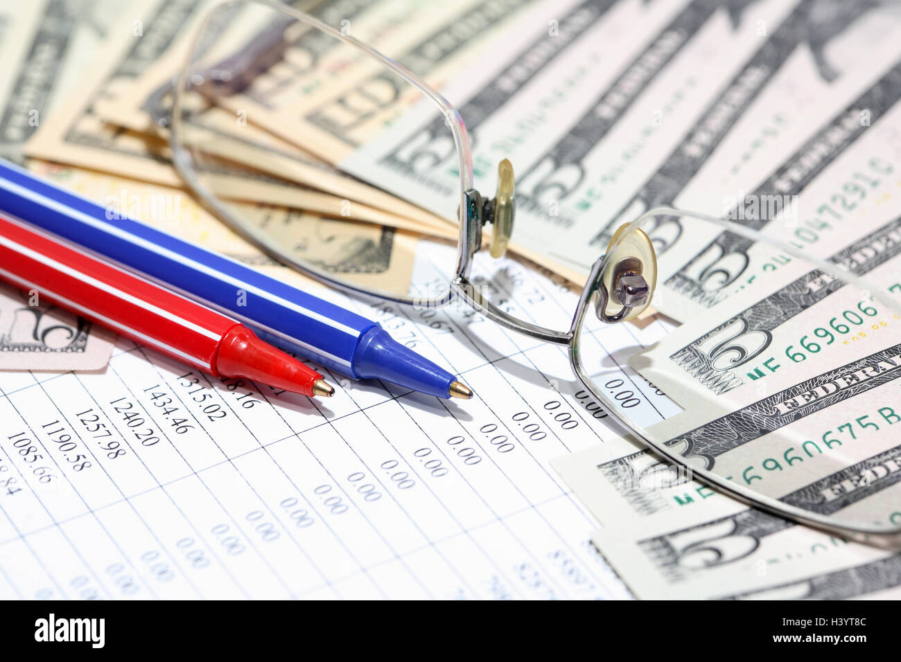Red and blue pens near money on paper background with digits Stock ...