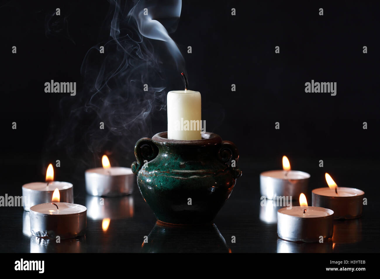 One extinguished candle among set of lighting candles Stock Photo - Alamy