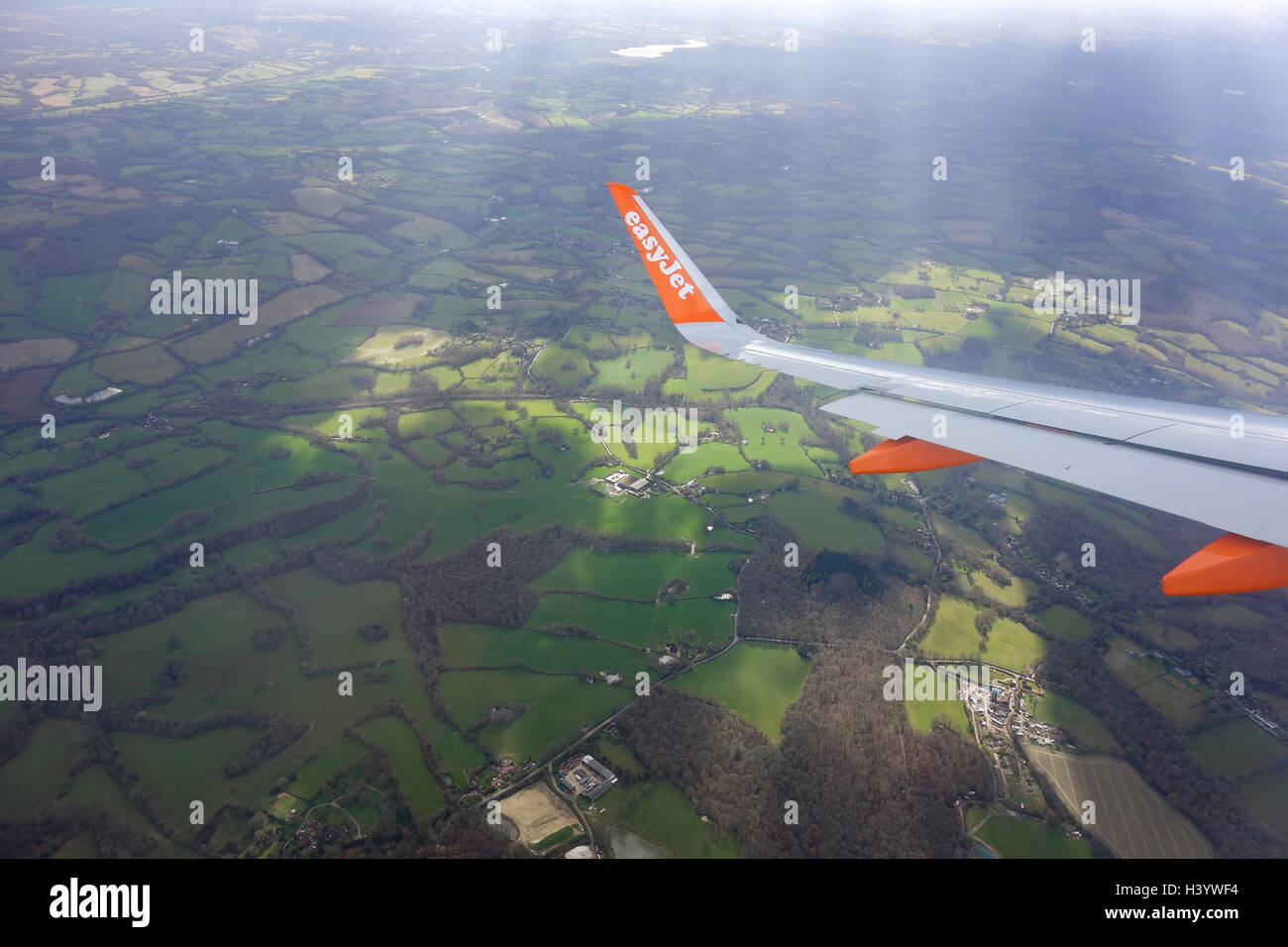 EasyJet passenger plane in flight over England, EasyJet logo on wing of ...