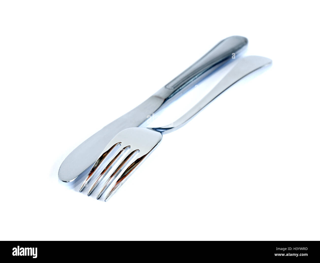 Steel shiny fork near knife on white background Stock Photo - Alamy