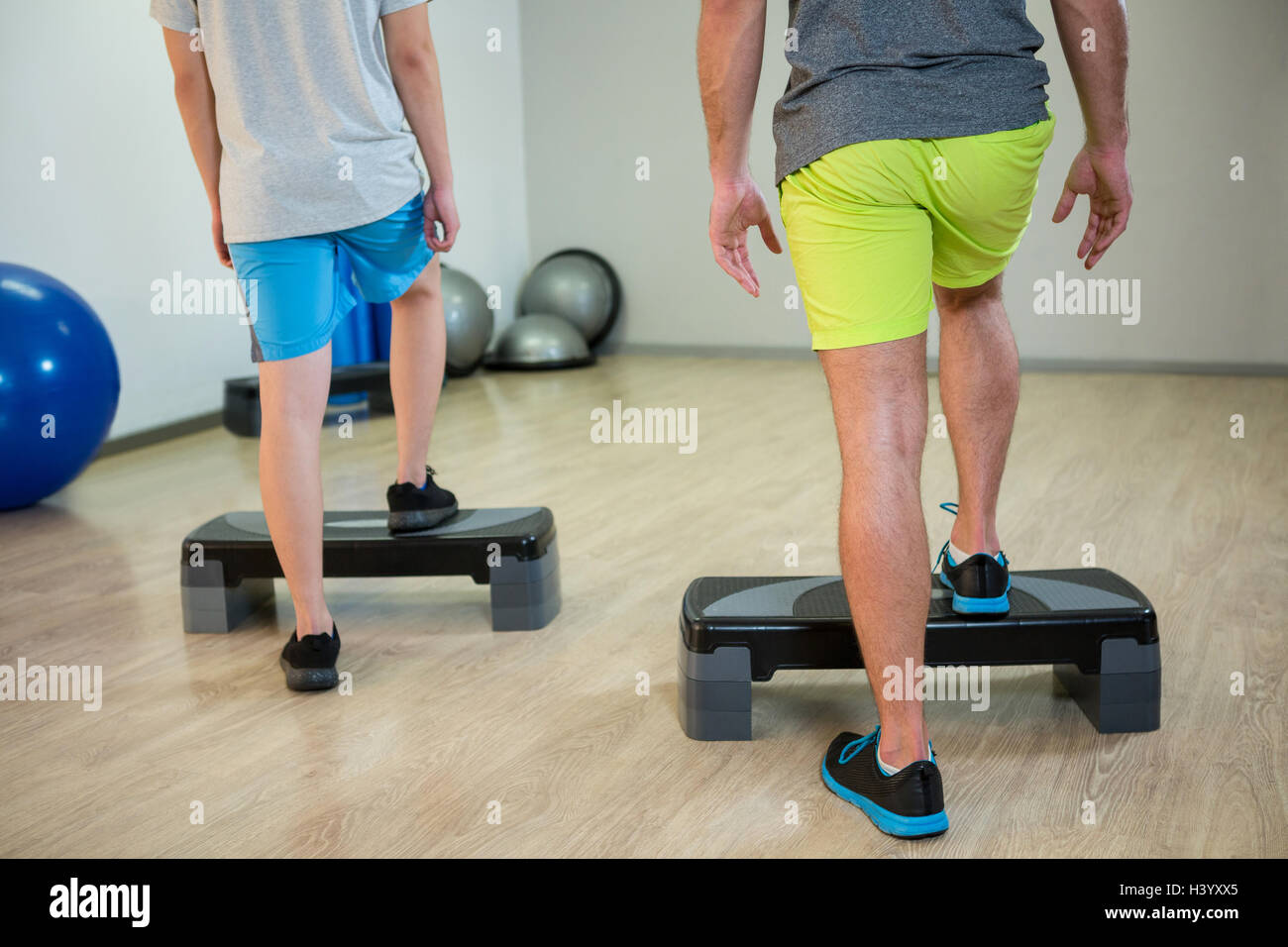 Two men doing step aerobic exercise with dumbbell on stepper Stock ...