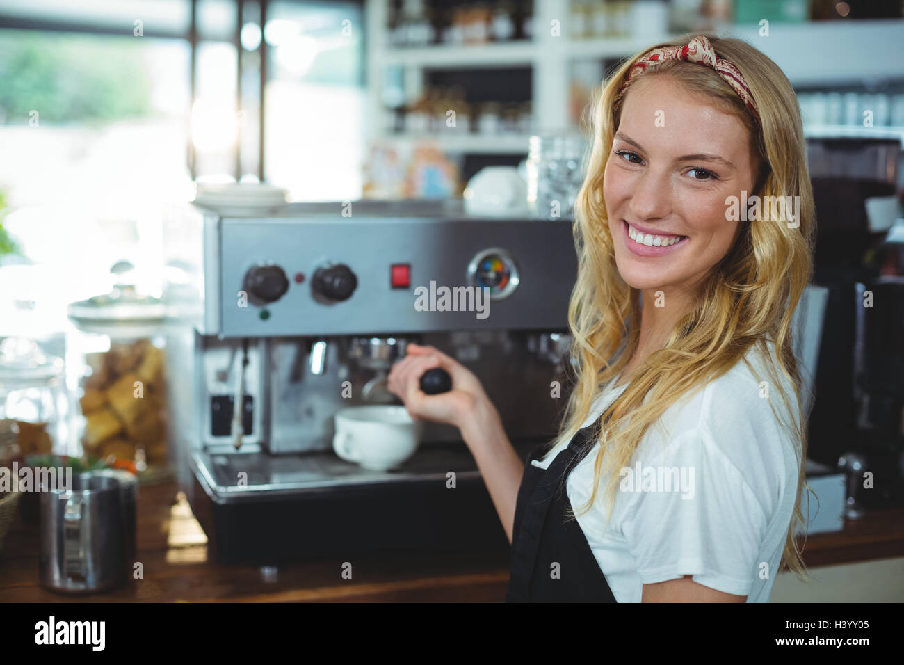 Portrait of smiling waitress making cup of coffee Stock Photo - Alamy