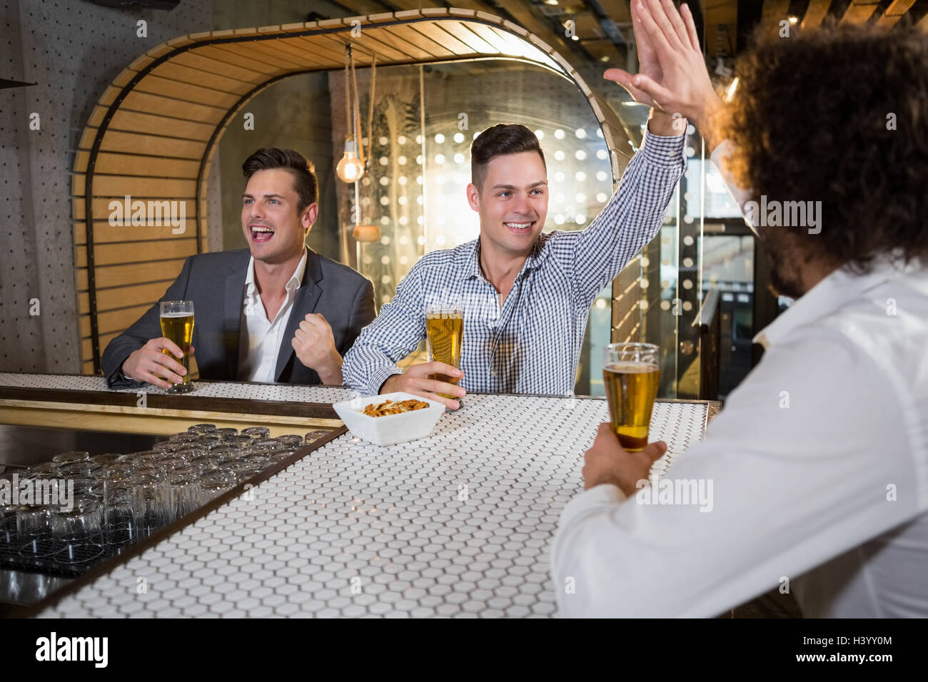 Friends giving high five while watching tv Stock Photo - Alamy