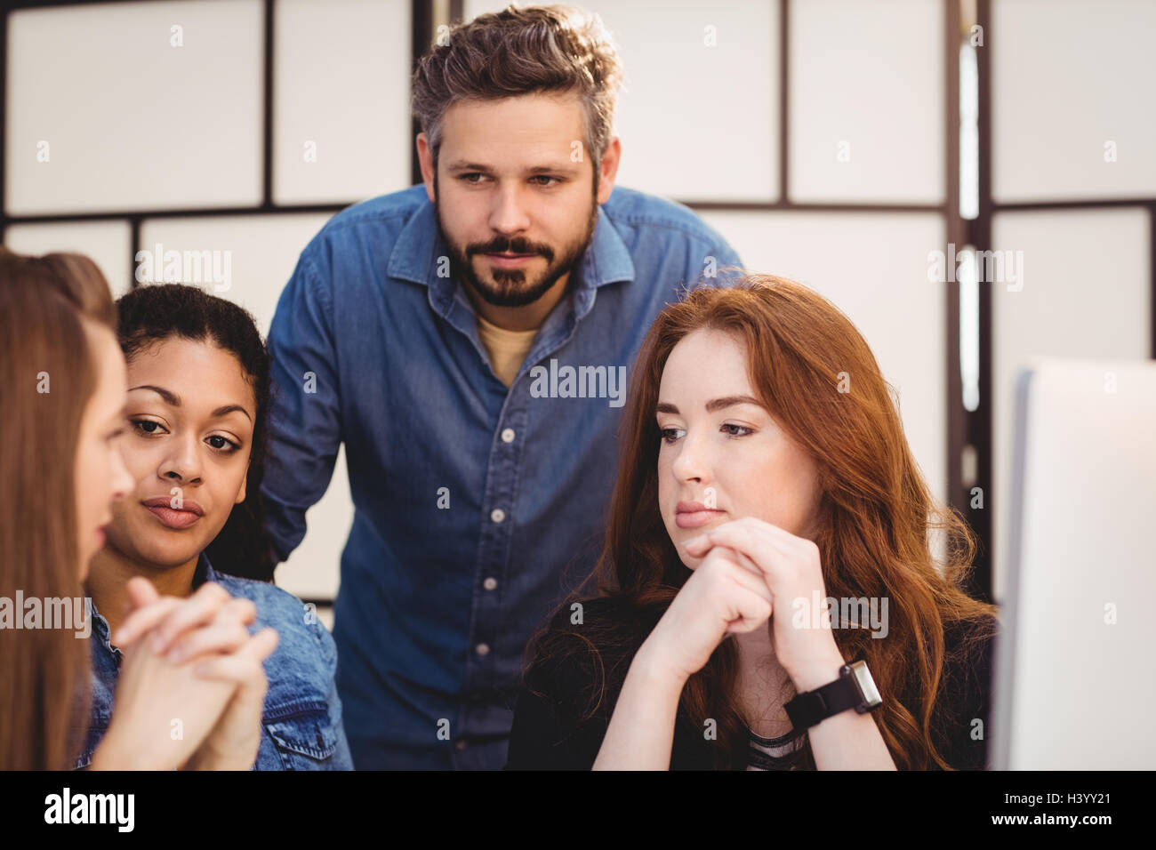 Business people looking at female coworkers Stock Photo - Alamy