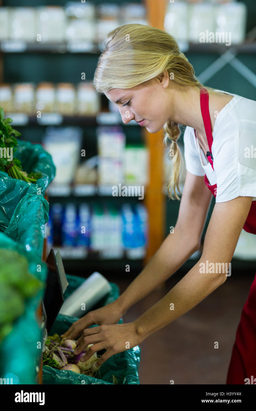 Female staff checking vegetables in organic section Stock Photo - Alamy