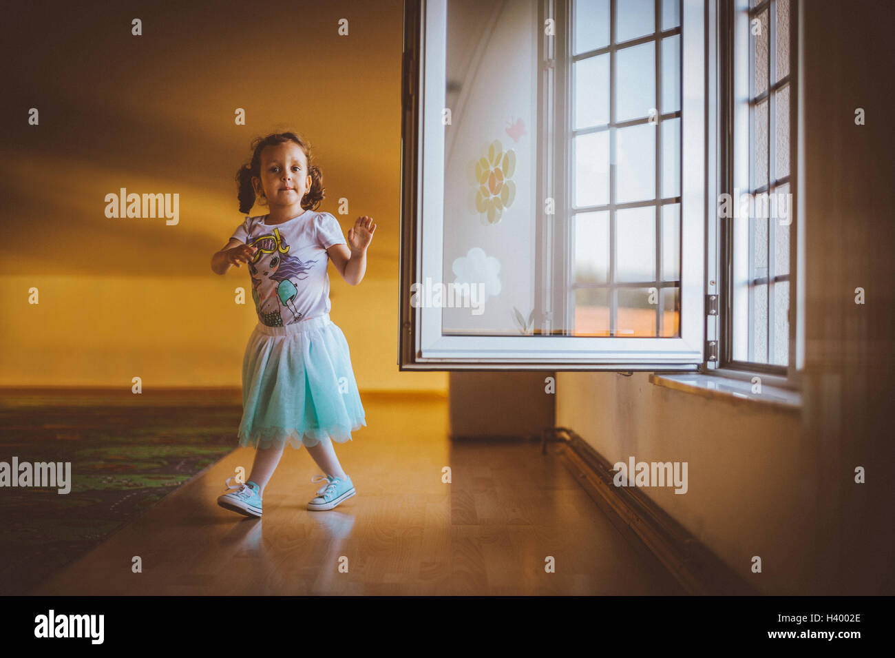 Girl walking past an open window Stock Photo - Alamy
