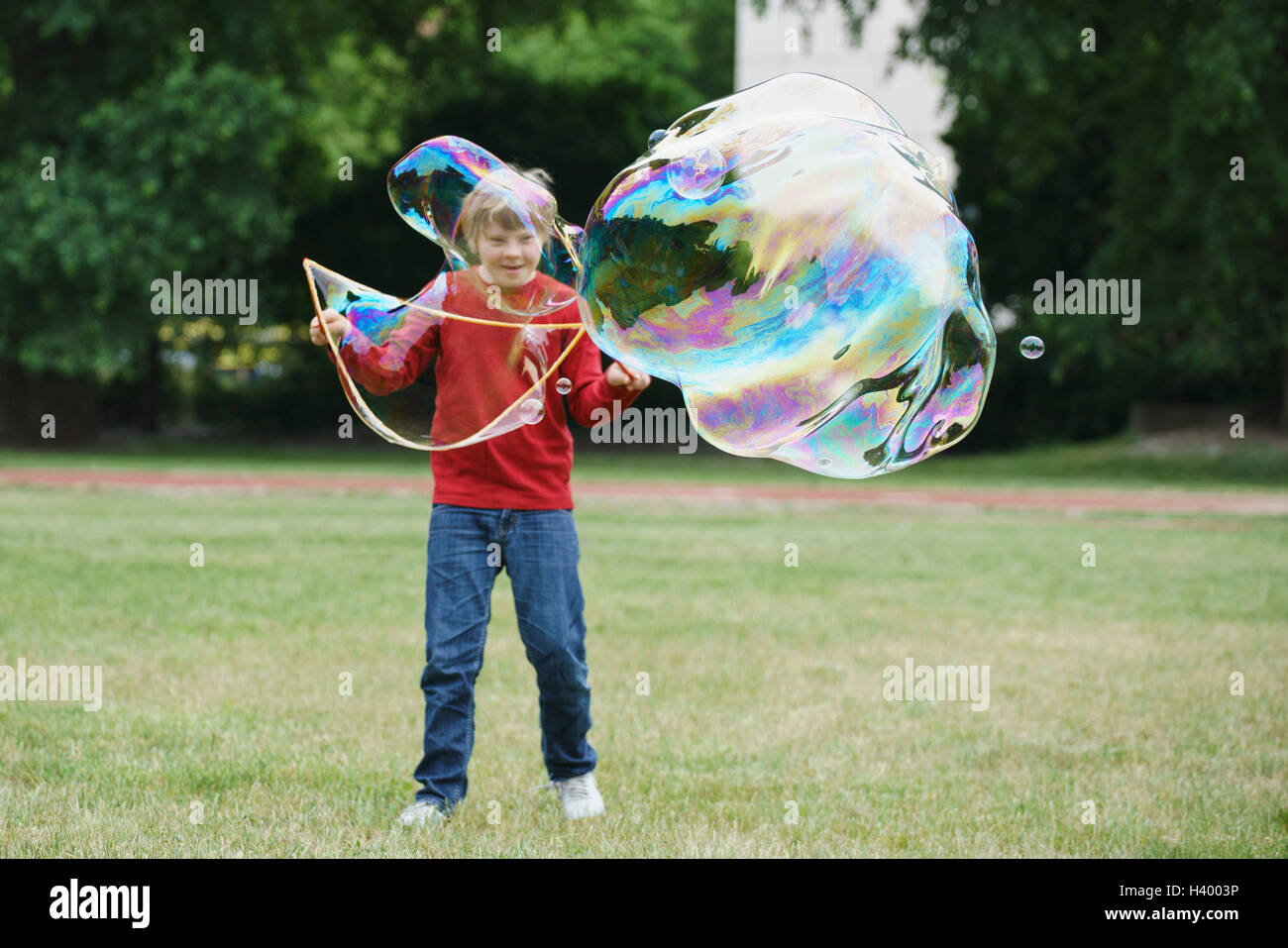 Boy playing with soap bubbles in back yard Stock Photo - Alamy