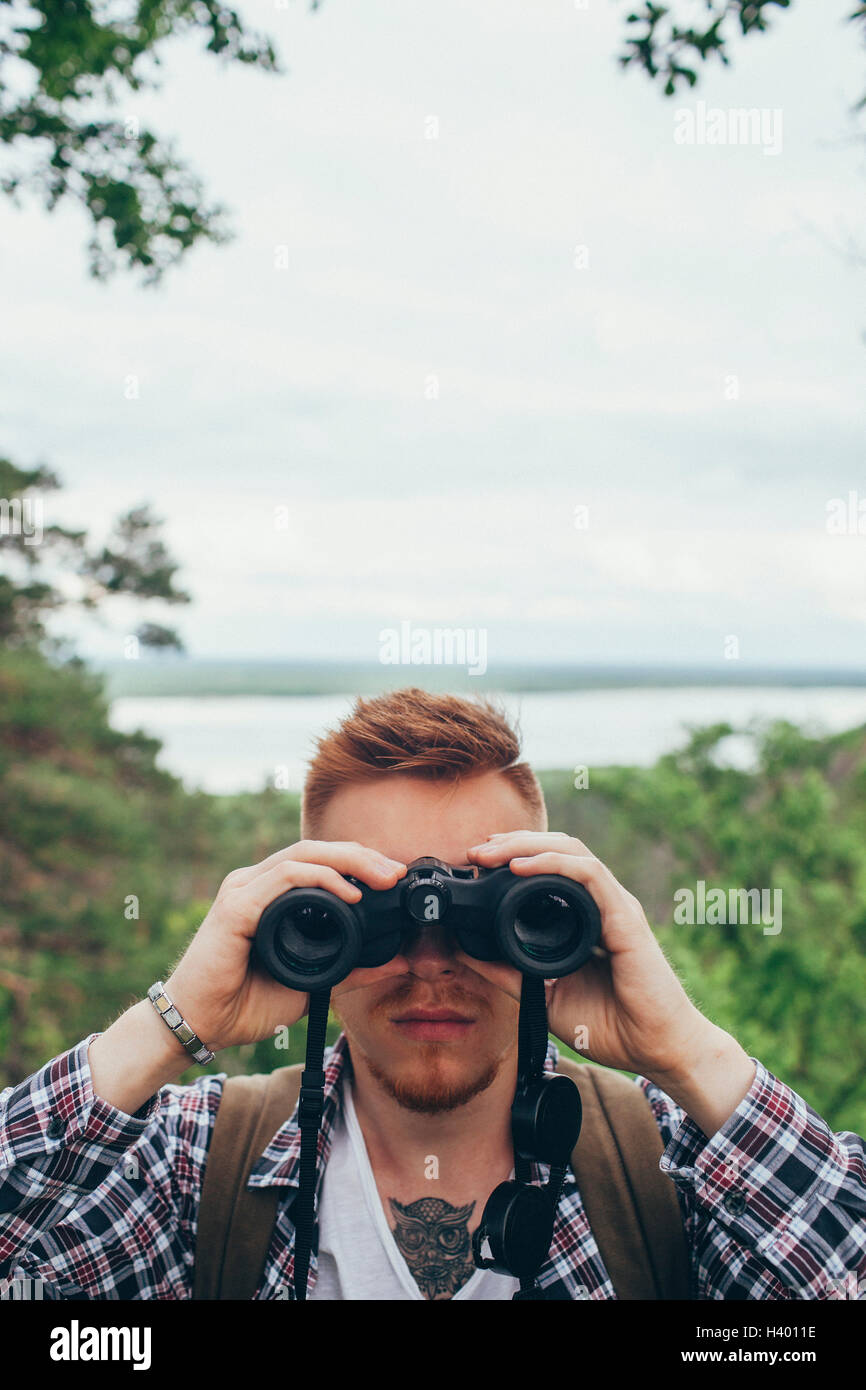 Man looking through binoculars standing hi-res stock photography and ...