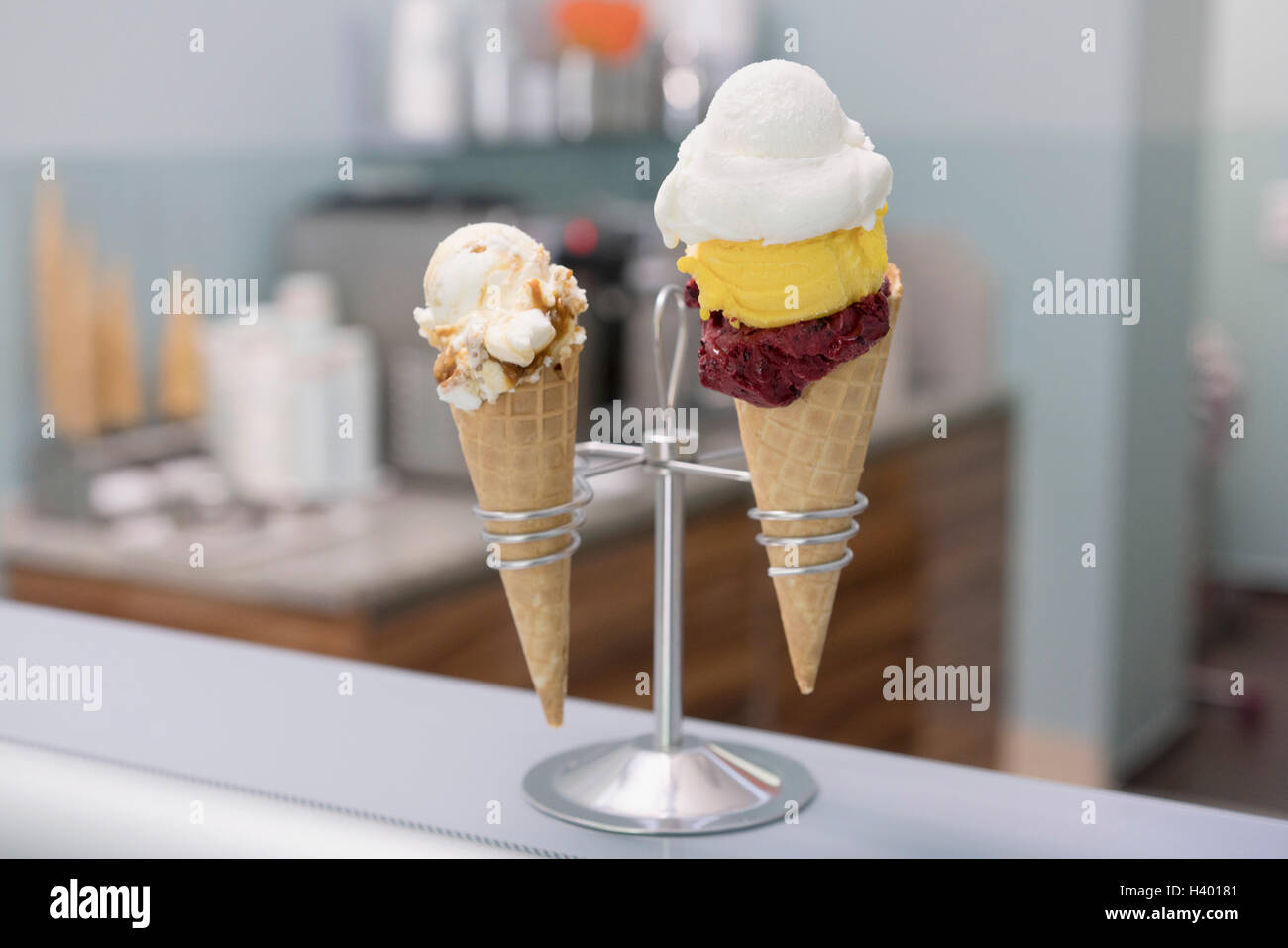Various ice cream cones in holder on counter at store Stock Photo - Alamy