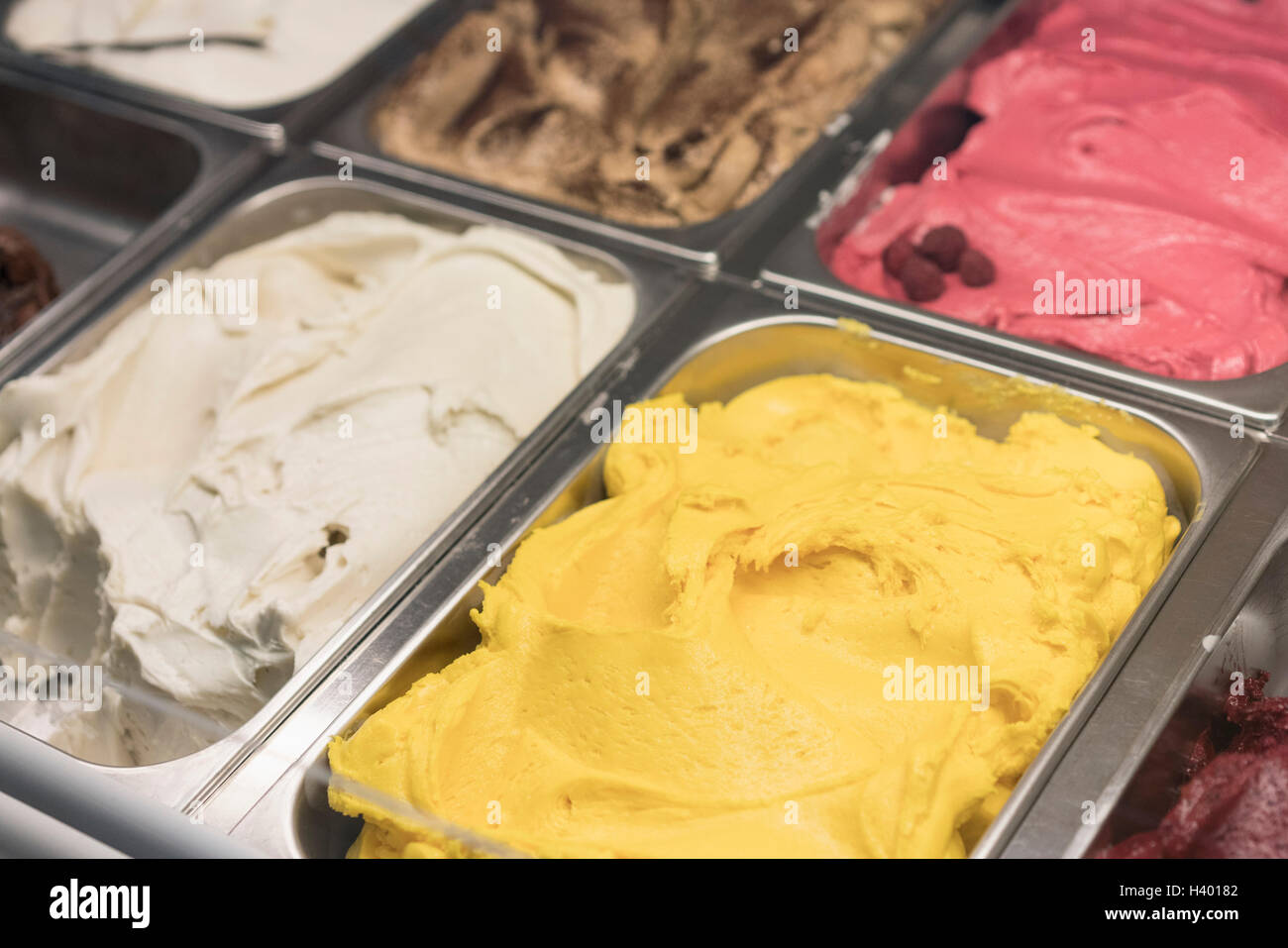 Various ice creams in containers on display at store Stock Photo - Alamy