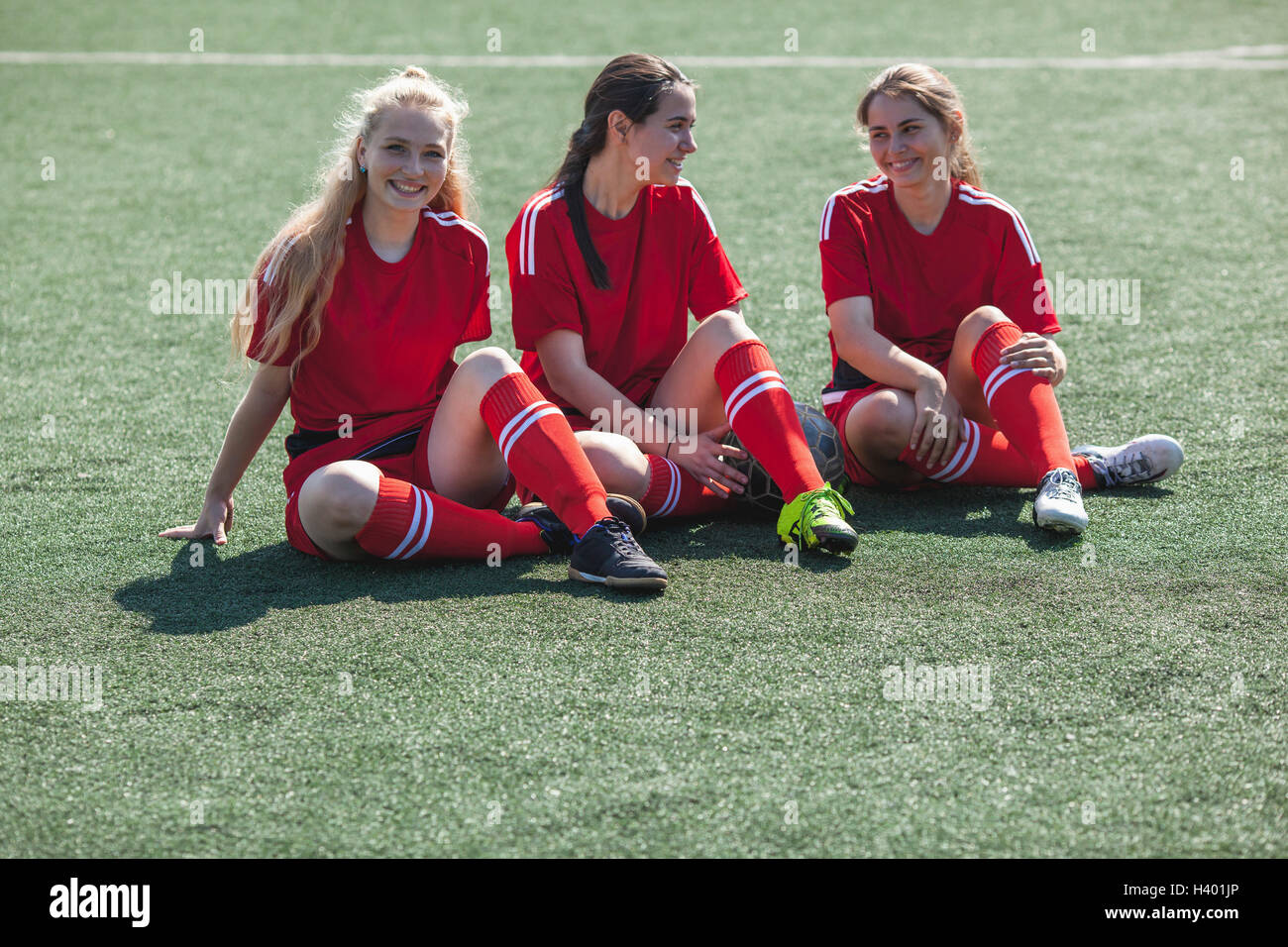 Cheerful soccer players talking while resting on field Stock Photo - Alamy