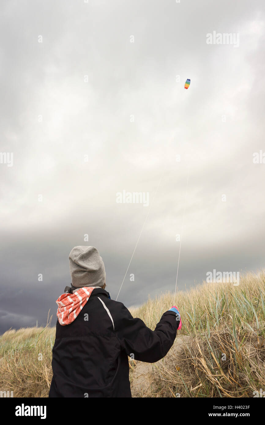 Rear view of boy flying kite against cloudy sky Stock Photo - Alamy