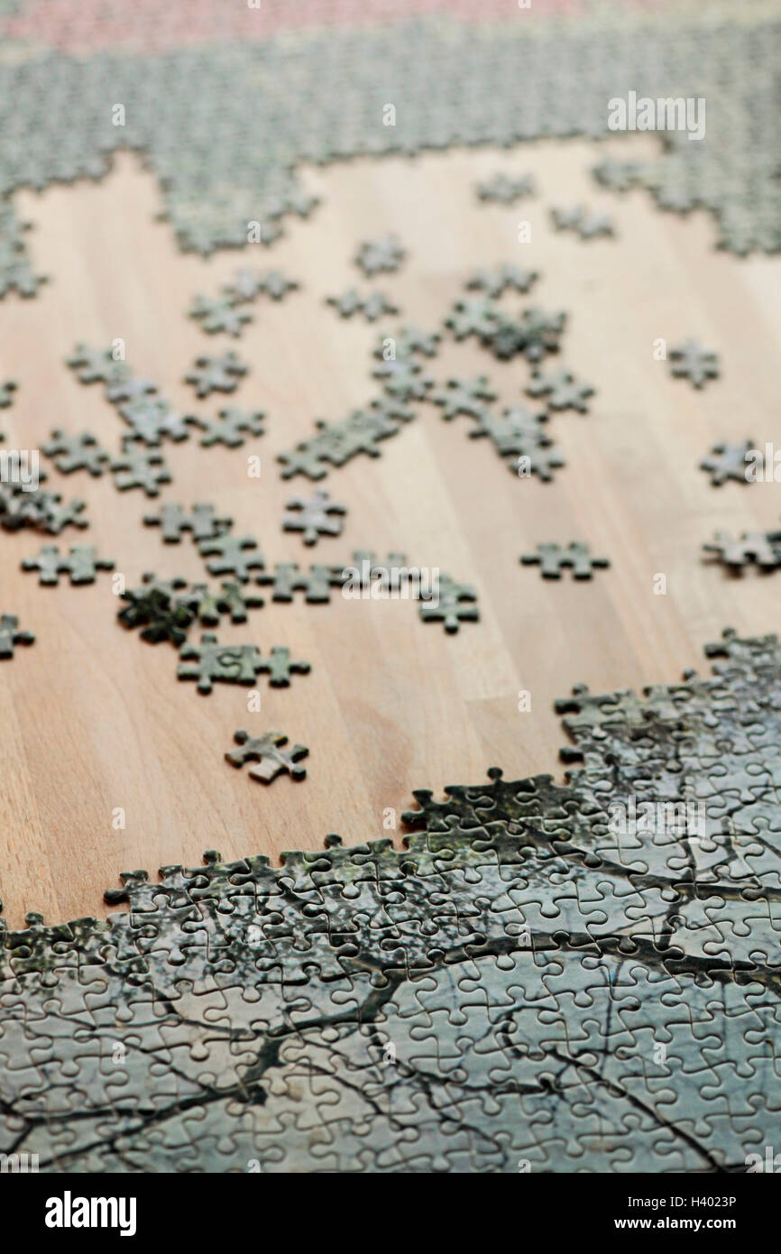 High angle view of jigsaw puzzle and pieces on wooden table Stock Photo ...