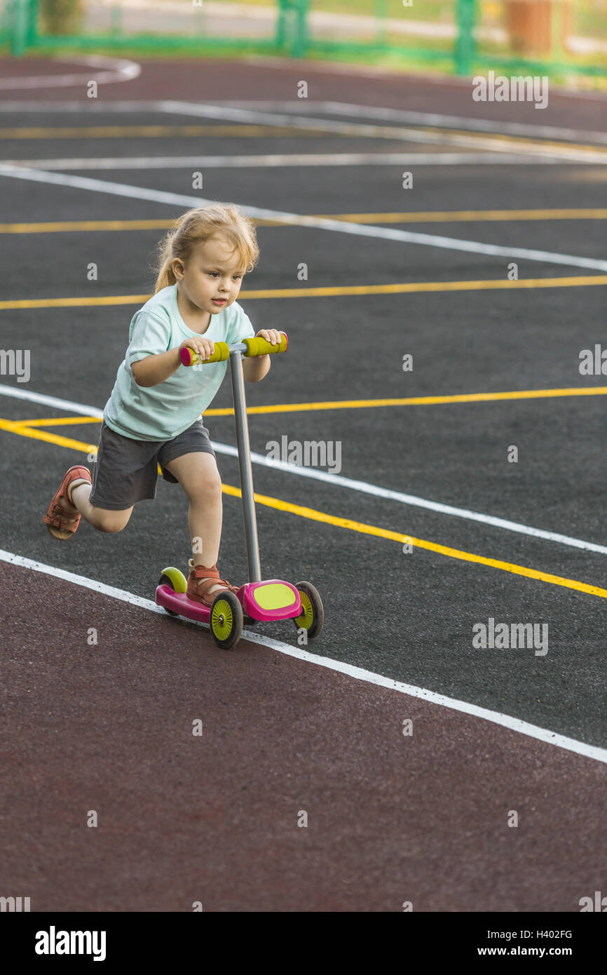Cute girl playing riding scooter hi-res stock photography and images ...