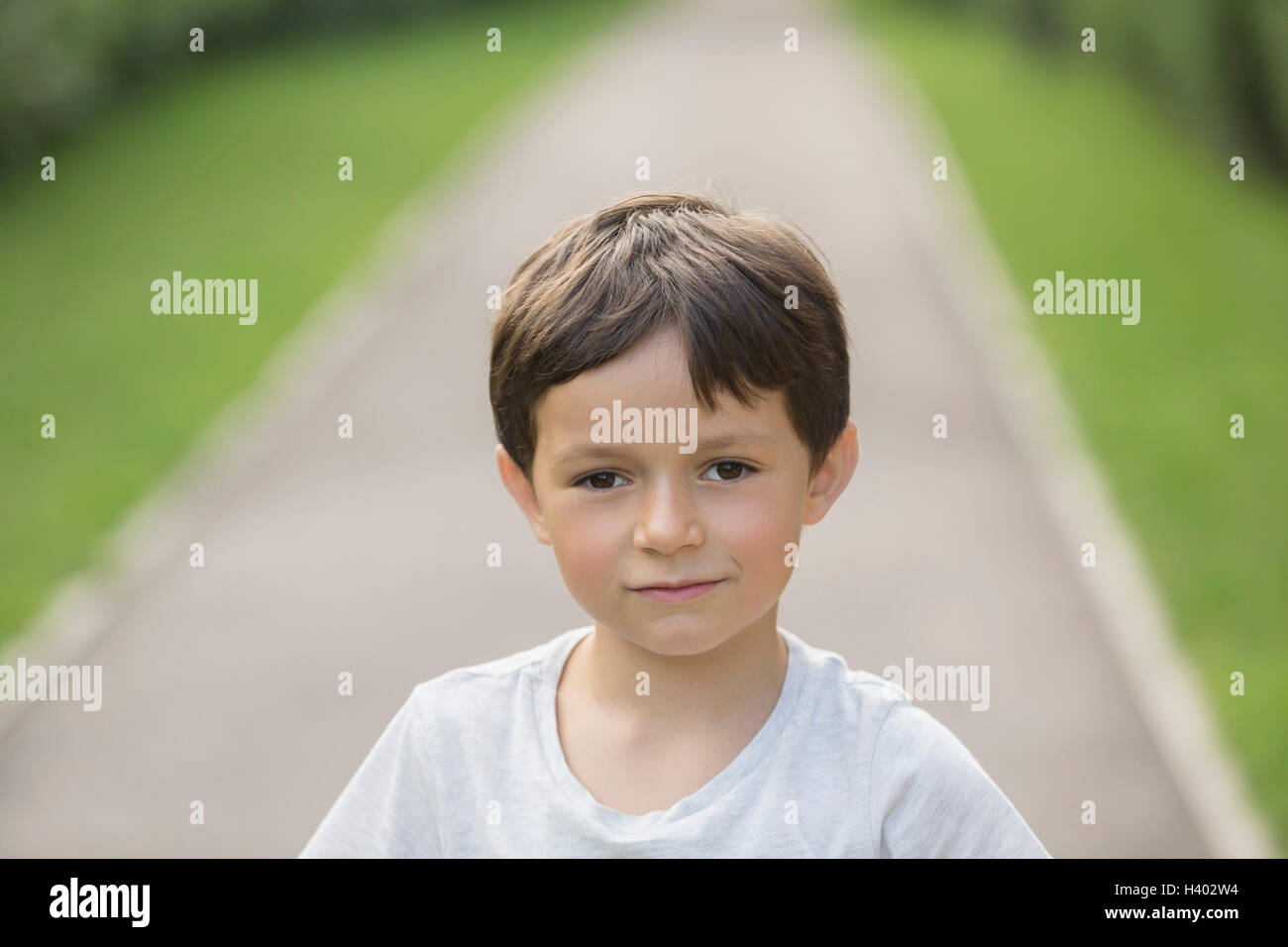 Portrait of cute smiling boy standing on road Stock Photo - Alamy