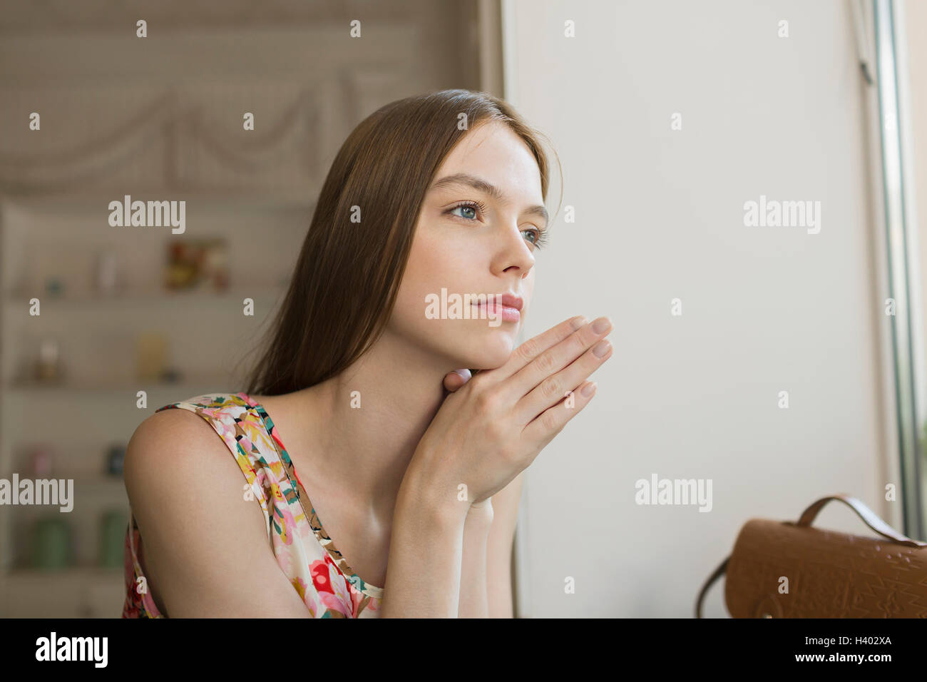 Thoughtful beautiful woman leaning by wall Stock Photo - Alamy